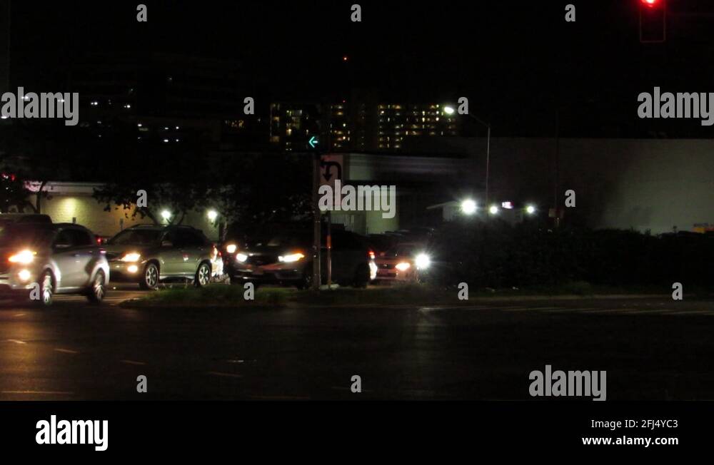 Traffic and cars turning in the intersection at night in Honolulu on ...