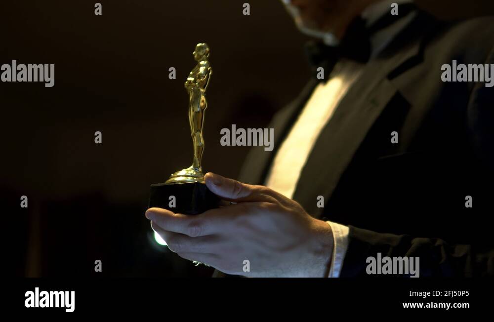 Camera Flashes as Man Receives Film Award Trophy At Red Carpet Event ...