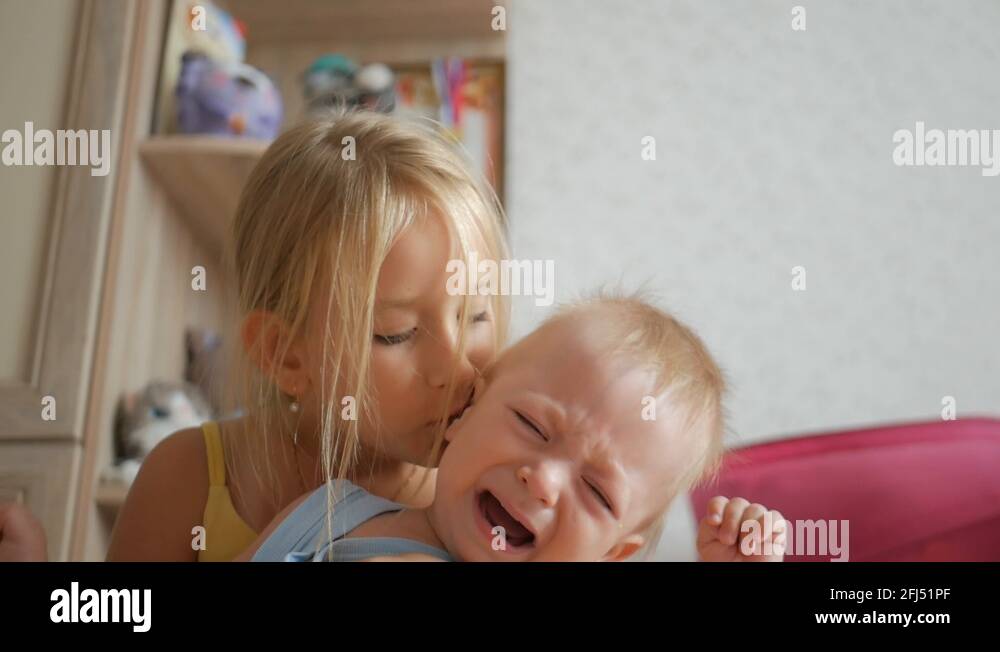 Older sister soothing little crying brother Stock Video Footage - Alamy