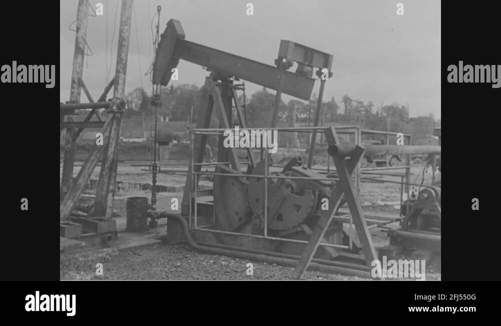 Scenes of workers look inside oil well frame and operation in oil ...
