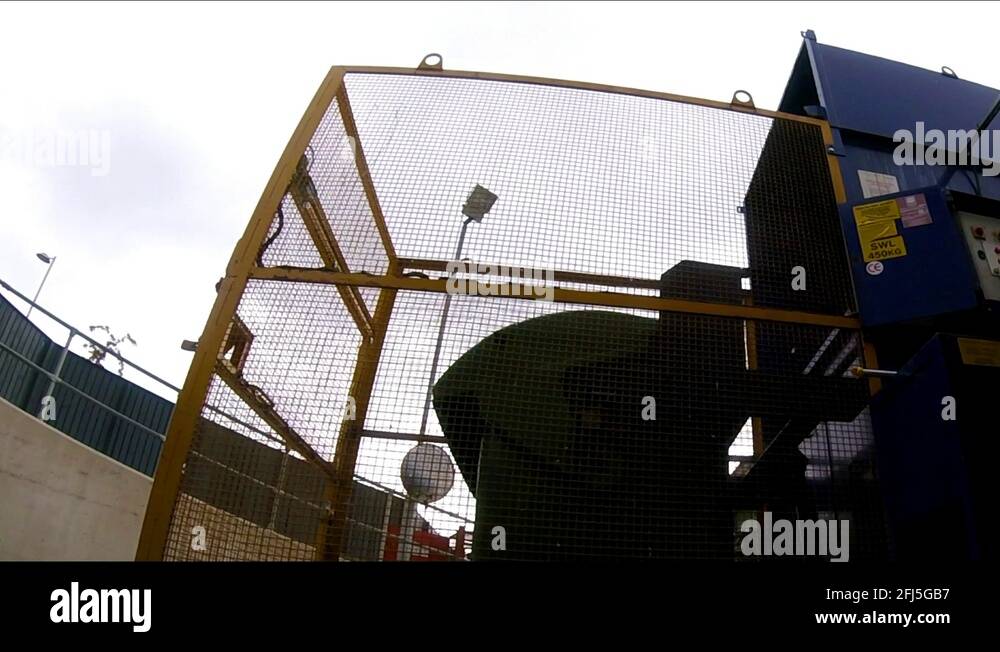 Operating a bin disposal machine. Emptying trash into compressor unit ...