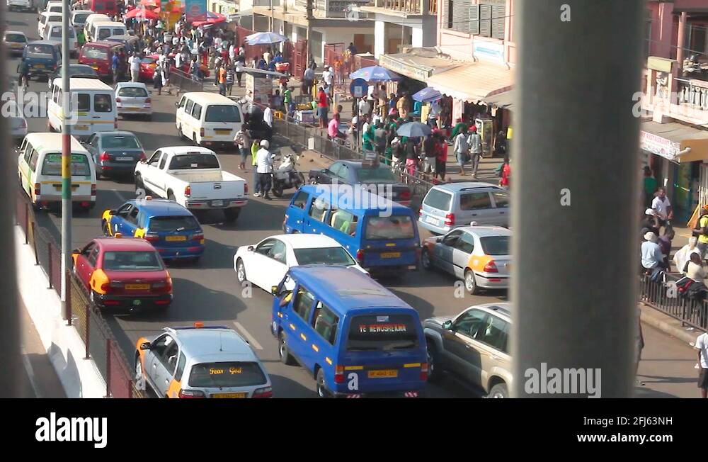 Close Overhead panning shot over cars and people ,Busy Streets of Accra ...