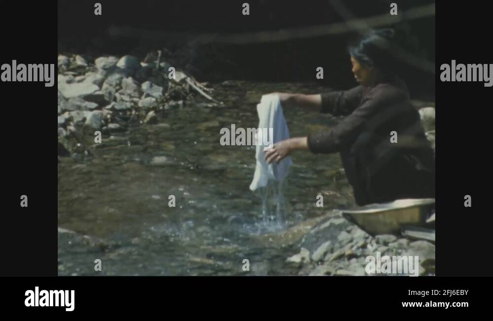 South Korean woman washing clothes in the stream and M48A2 tank parked ...