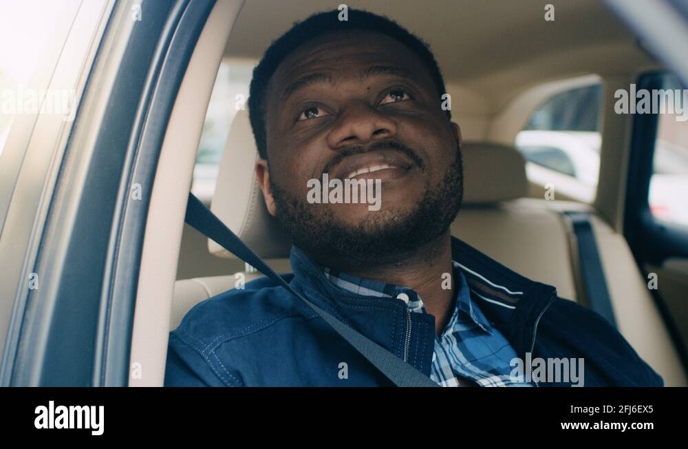 Handsome Young Black Man Rides on a Passenger Seat of a Car, Looks in ...