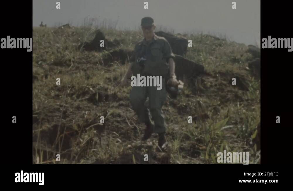 ROK Soldiers fire M101 howitzer gun while shells explode atop mountain ...