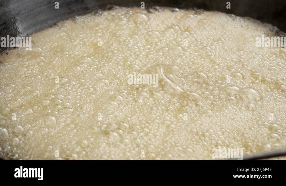 Closeup of rice in boiling water in a big wok at a street market in ...