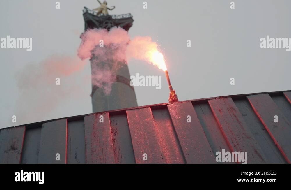 Red smoke flare behind a police barricade at a riot at Place de la ...