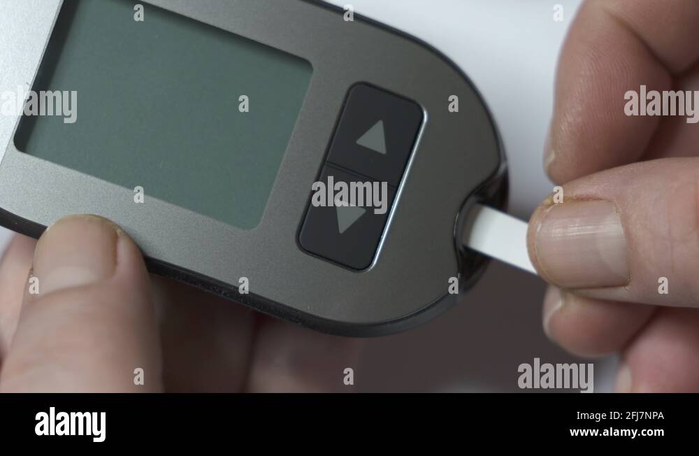 Patient with diabetes using blood glucose meter and diabetic logbook ...