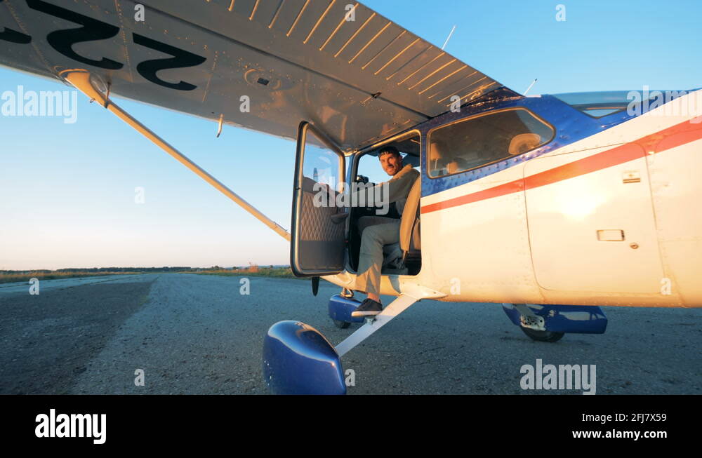 A pilot is sitting in cropduster's cockpit, winking and closing the ...