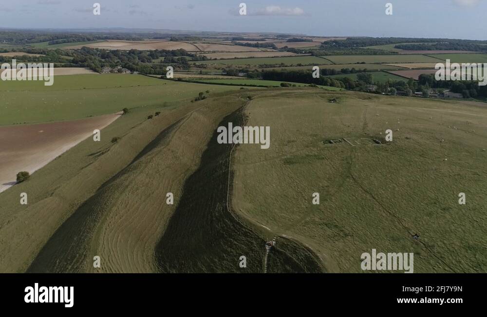 Aerial tracking down between the outer ramparts of the iron age hill ...