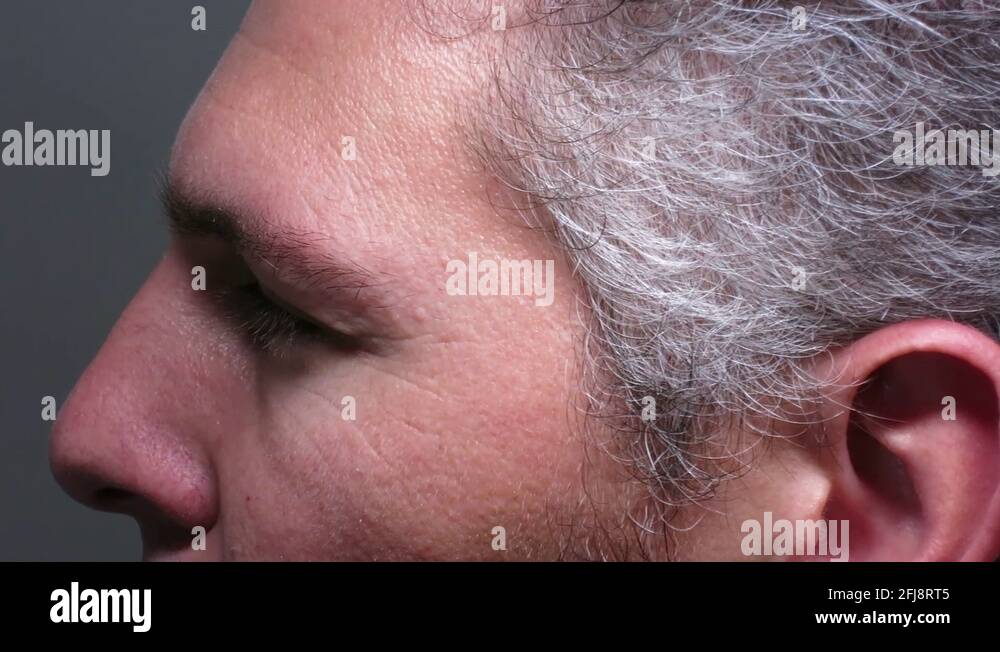 a man's face rotates in front of the lens from left to right, close up ...
