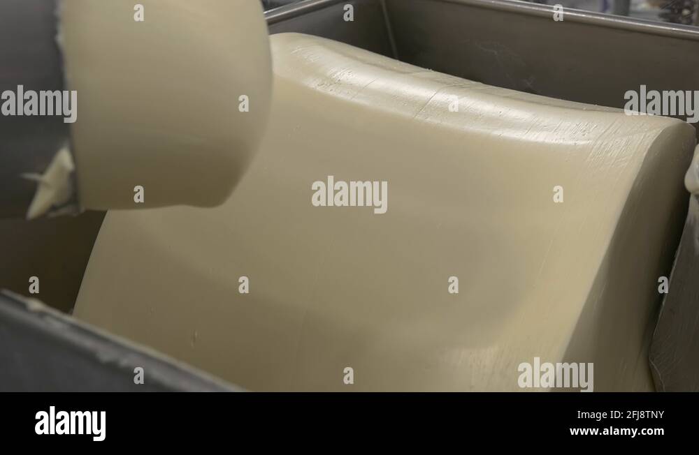 The Production of Butter at the Dairy Plant. Butter is Pouring From the ...