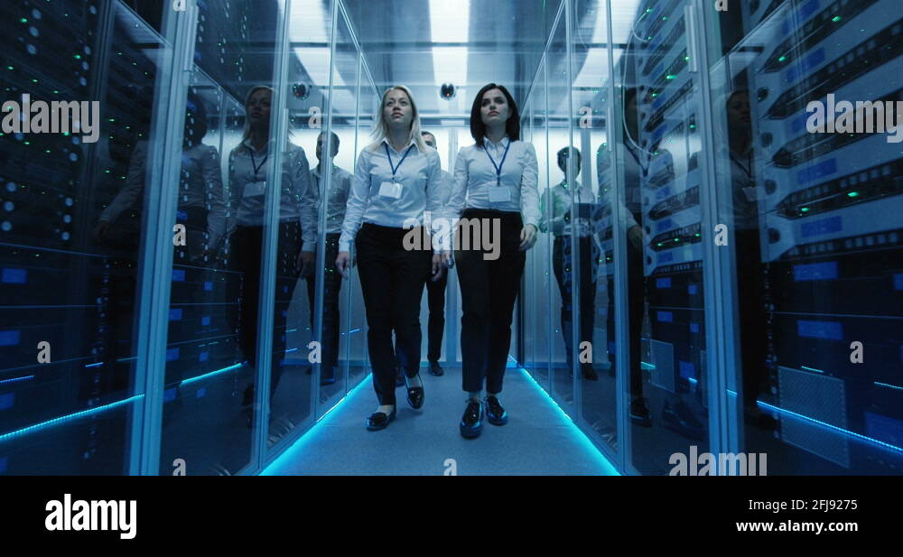 Workers in a data center walking between rows of server racks Stock Video Footage - Alamy