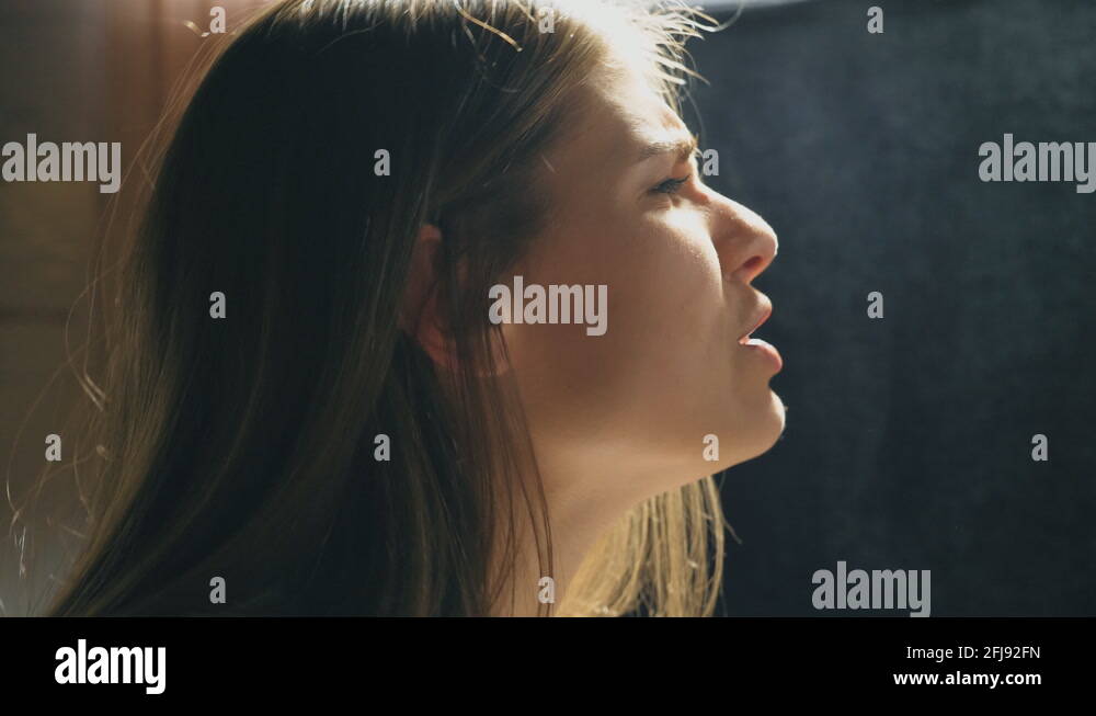 Profile of beautiful girl singing in sound studio. Young singer sings ...