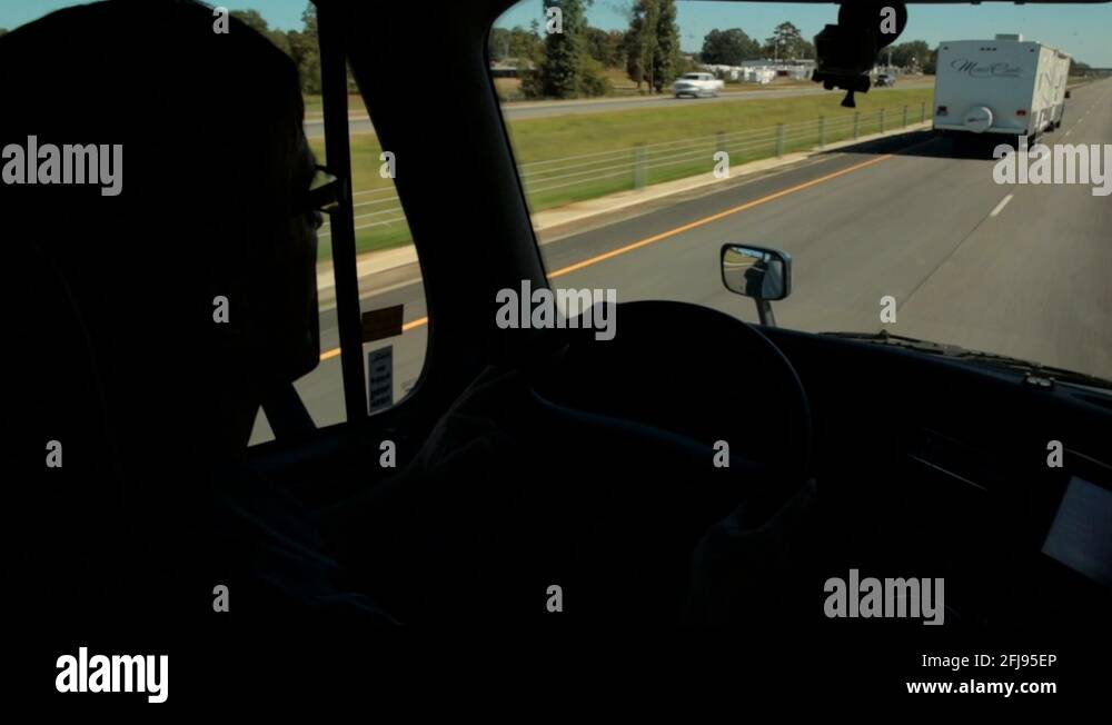 Man inside semi truck cab looking out and driving on highway Stock ...