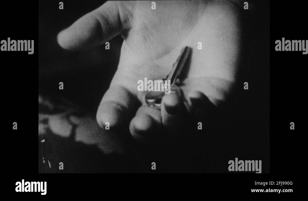 1940s: UNITED STATES: key in palm of hand. Lady opens door of house ...