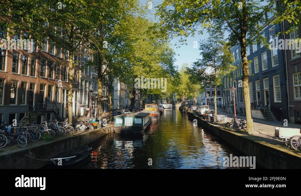 Beautiful places in Amsterdam - a cozy channel with barges, traditional ...