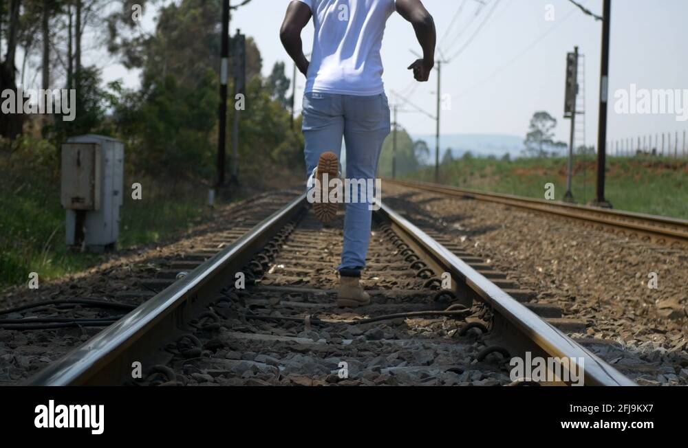 African stock video of a black man running away on a railway line Stock ...