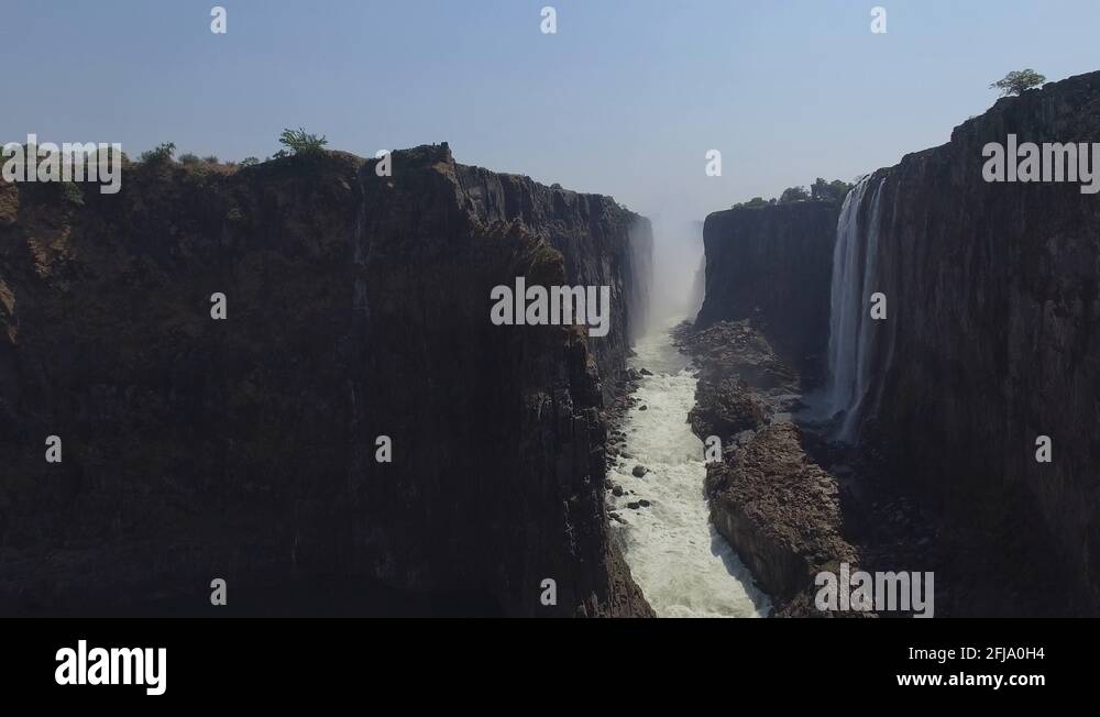 Drone shot of a big waterfall and Devils Pool at Victoria Falls during ...