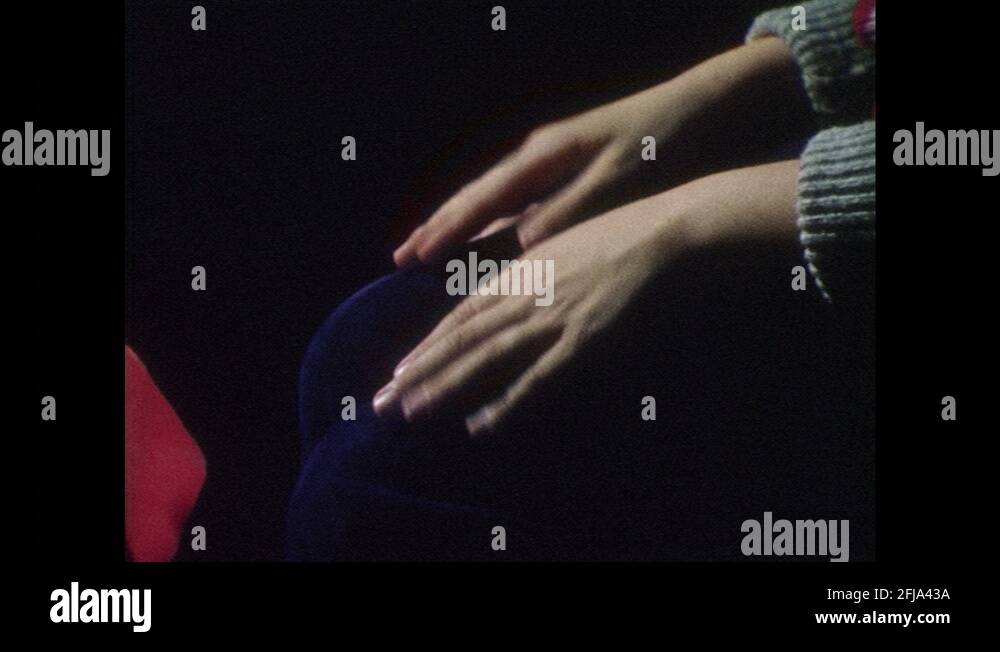 1960s: Boy's hands patting on legs while playing pattycake. Girl's face ...