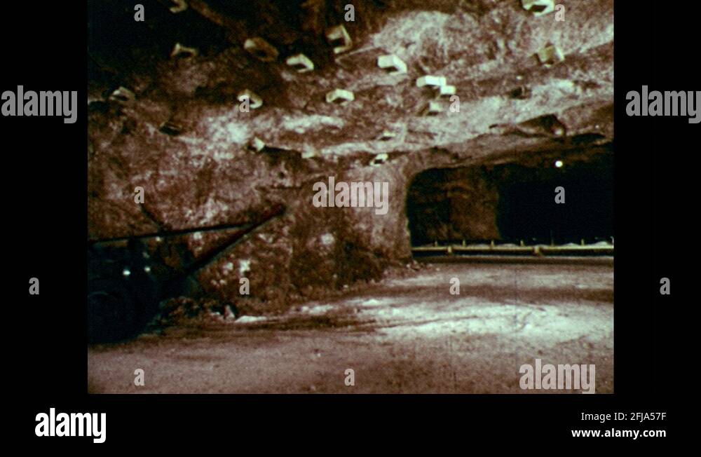 1970s: Two people ride vehicle through mine tunnel, then stop to allow ...