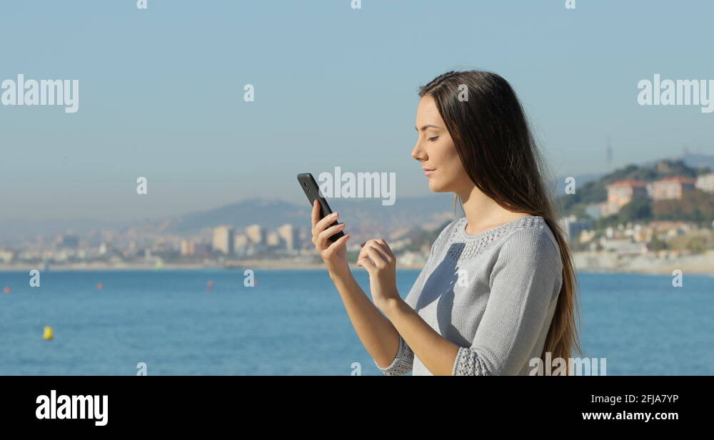 Surprised woman on phone on the beach Stock Video Footage - Alamy