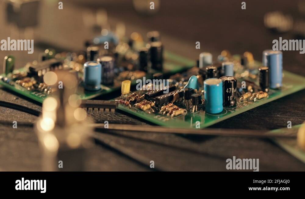 Assembling a circuit board. Putting microcircuit on PCB with tweezers ...
