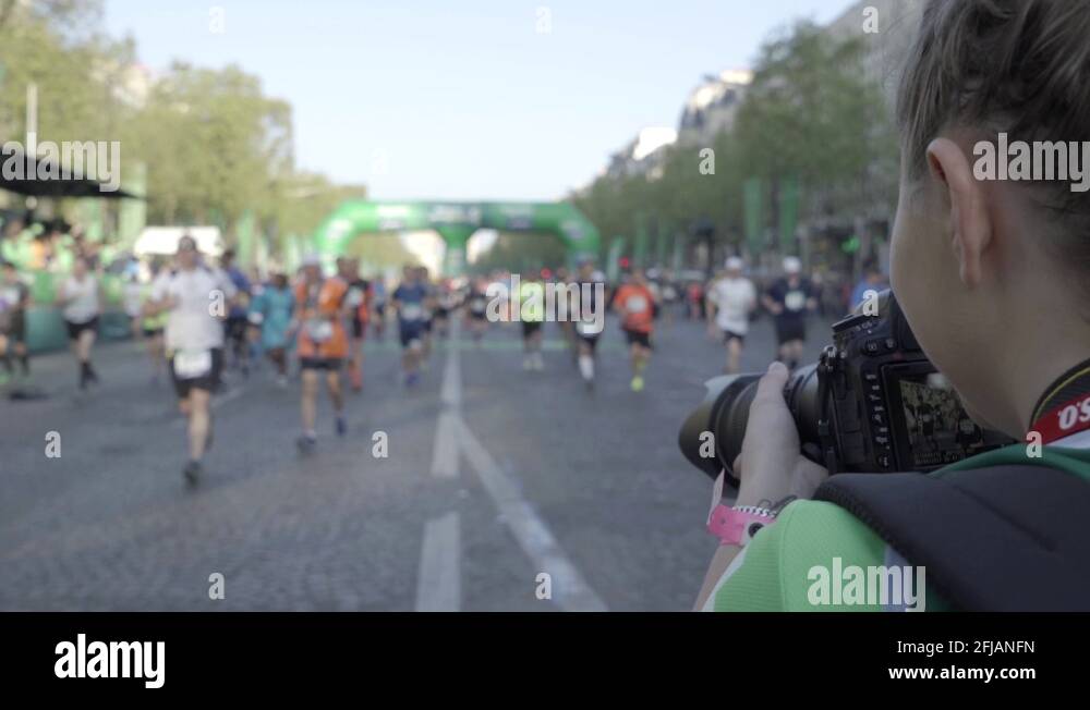 Young female photographer is shooting Marathon runners a few moments ...