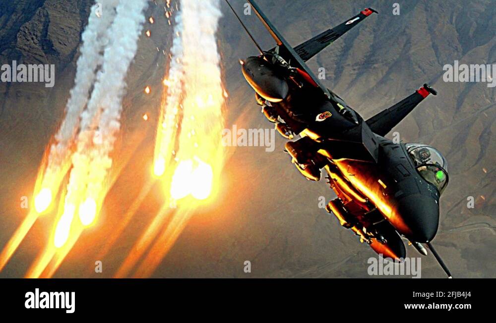 Military fighter jet launches missiles at mountain target cinemagraph ...