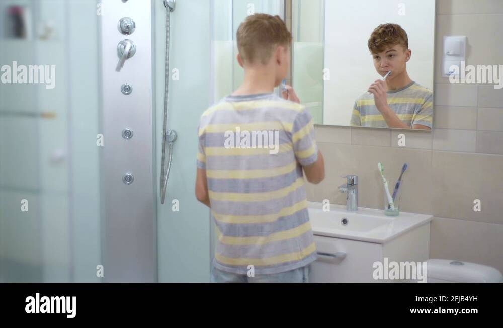 Teen boy brushing teeth Stock Video Footage - Alamy