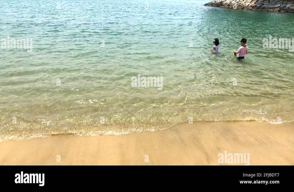 Two kids playing at the beach in Sentosa Singapore Stock Video Footage ...