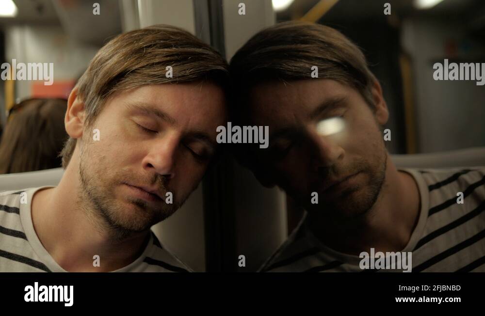 man sleeping in a underground Metro subway train. Tired worker student ...