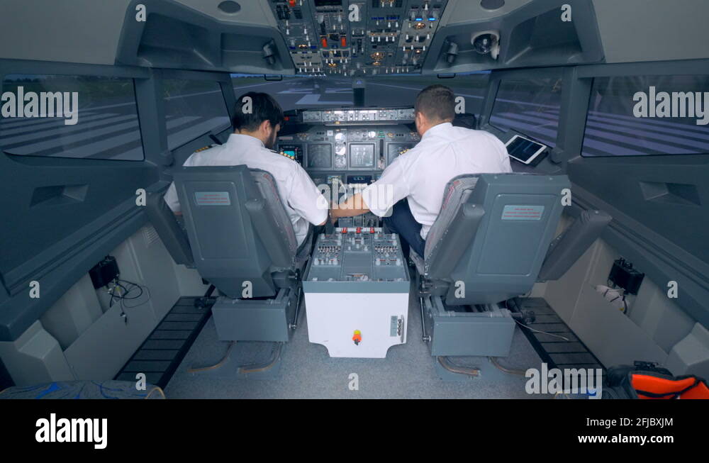 Two pilots check equipment in a cockpit, back view Stock Video Footage ...
