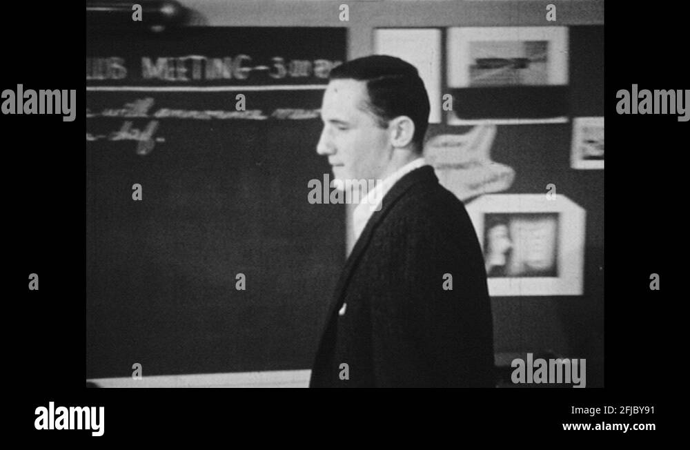 1950s: Boy in sports coat walks through classroom and greets students ...