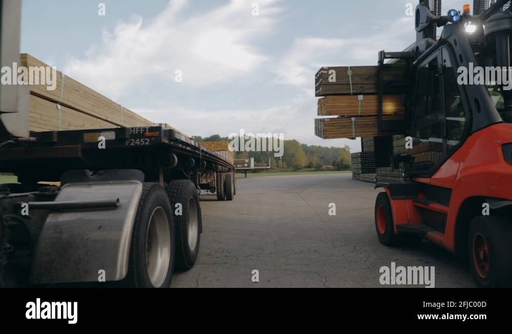 Forklifter loading treated lumber on flatbed trailer Stock Video ...
