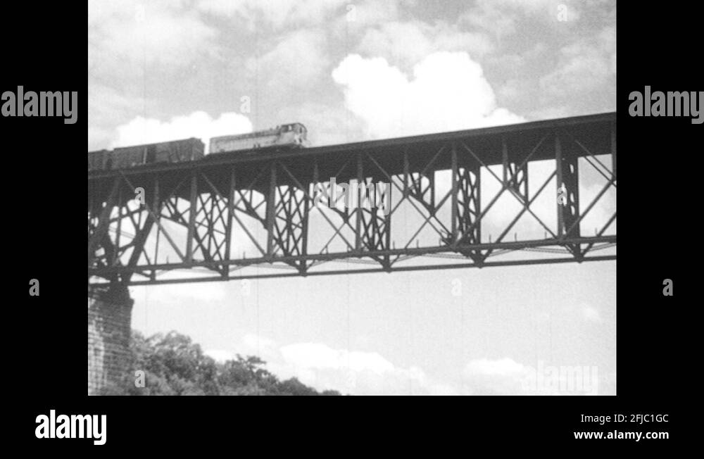 1950s: Low angle view, train on bridge. Close up of sail on toy boat ...