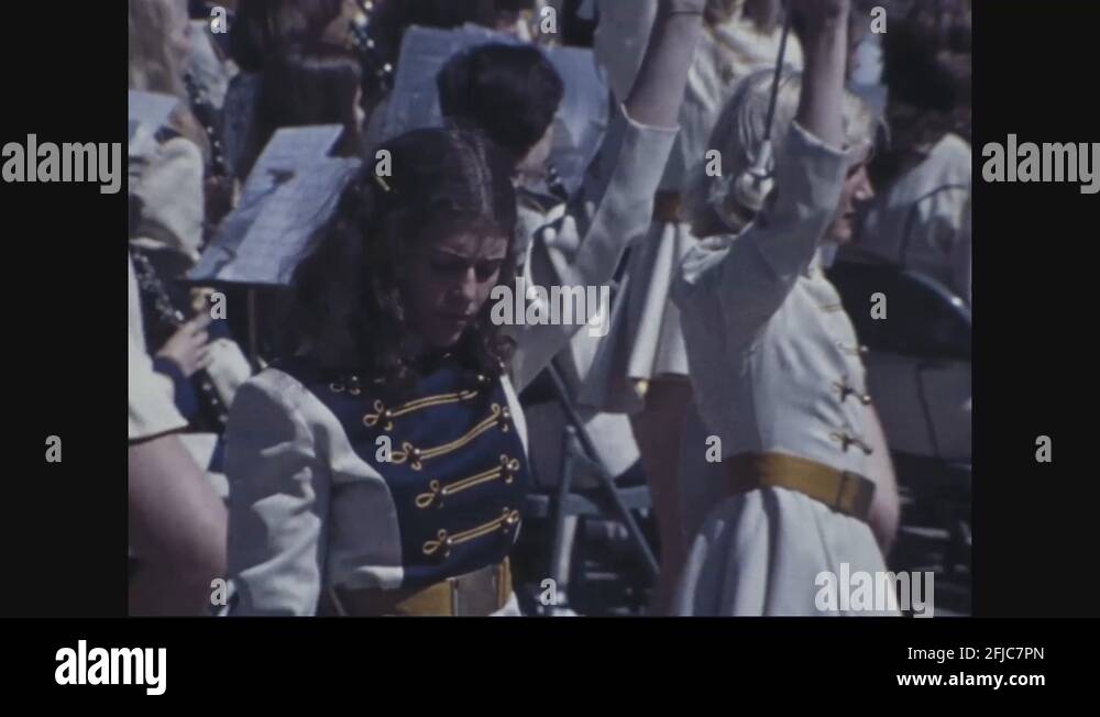 Flag twirlers and majorettes perform during ceremony and spectators ...