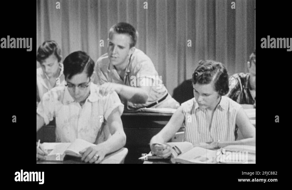 1950s: Boy grabs student should and speaks at desk. Boy takes book from ...
