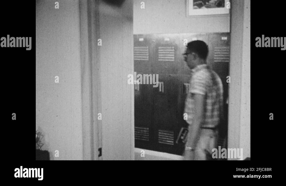 1950s: Students walk by classroom doorway. Boys and girl walk into ...