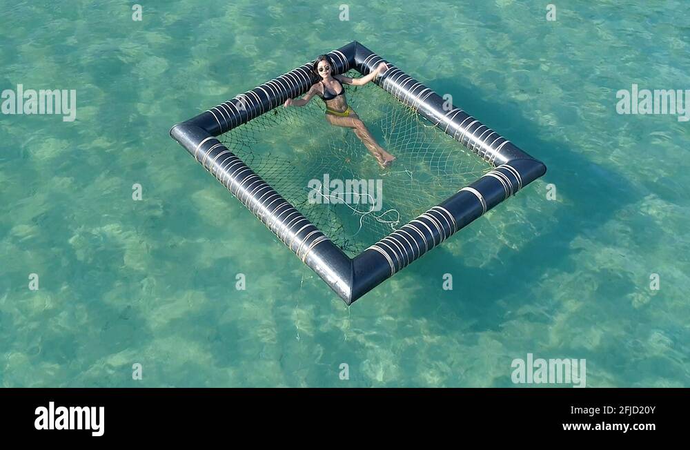 Girl sitting alone in a floating device in the ocean, Koh Kood ...