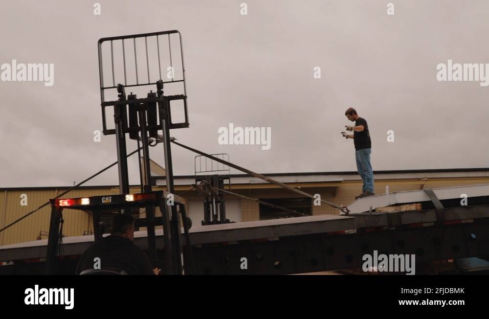 Men loading flatbed trailer attached to Peterbilt semi truck with Stock ...