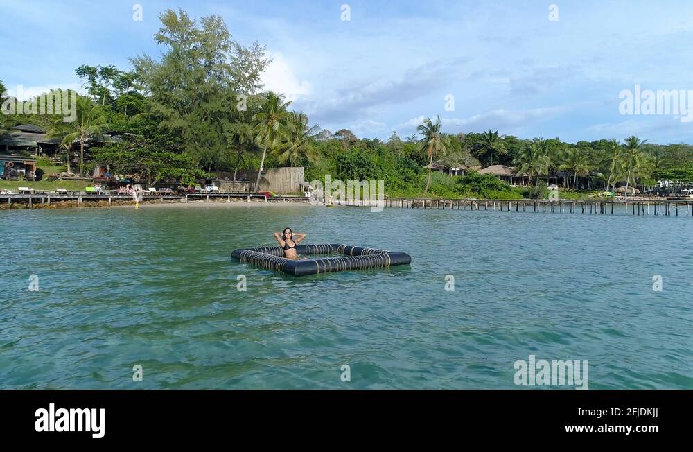 Girl relaxing in a floating device alone in the ocean, Koh Kood ...