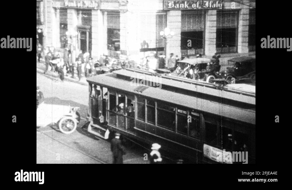 1920s: Cars, trolleys and pedestrian traffic in city intersection. Cars ...