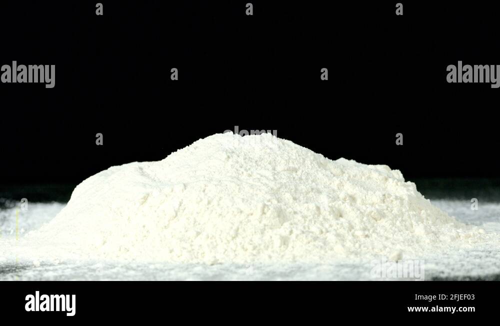Slow Motion Footage of an Egg Dropping into Flour, Against a Black ...