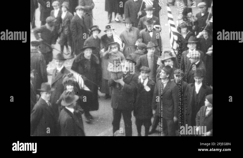 1920s: Crowds wave flags. Police officer on horse rides through crowd ...