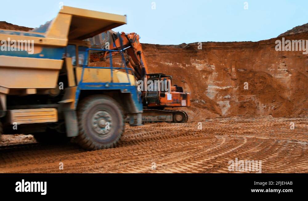 Excavator loading sand into tipper truck. Caterpillar excavator digging ...