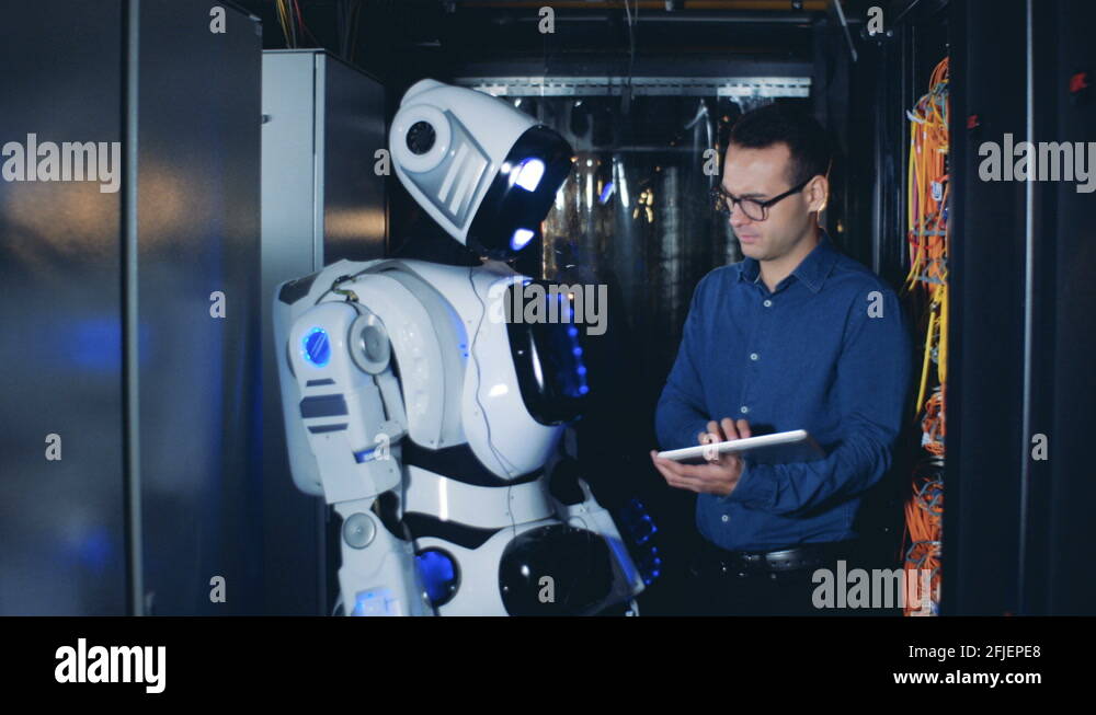 Male IT programmer and robot, droid work at a data center Stock Video ...