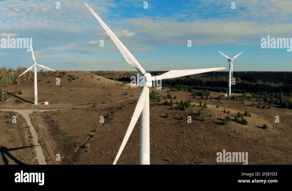 Wind towers working on a farm field. Wind generator, wind turbine from ...