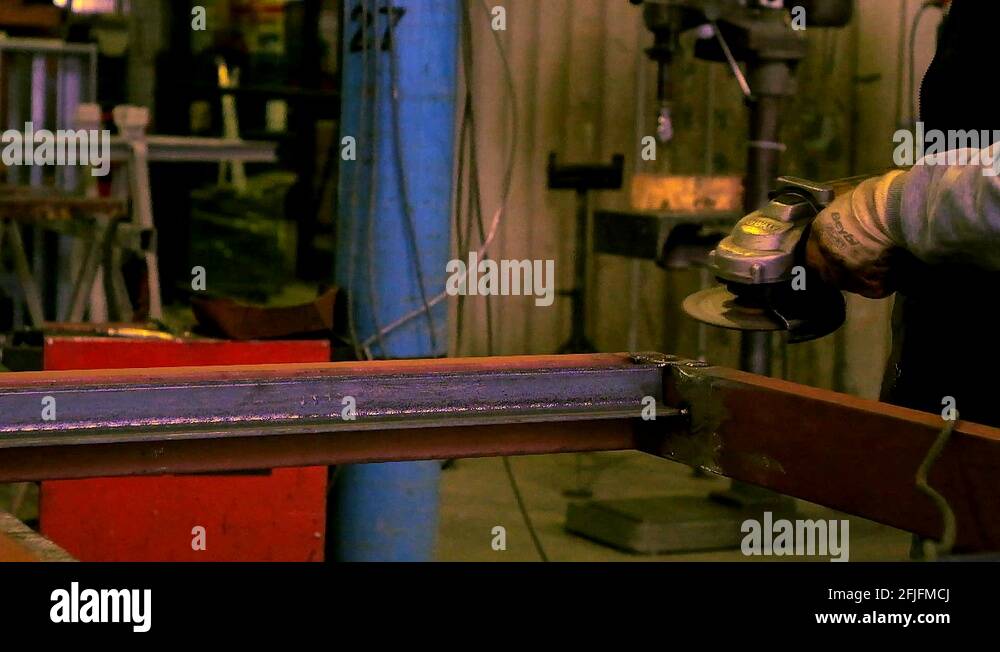 slow motione for a worker using the grander in a metale workshop Stock ...