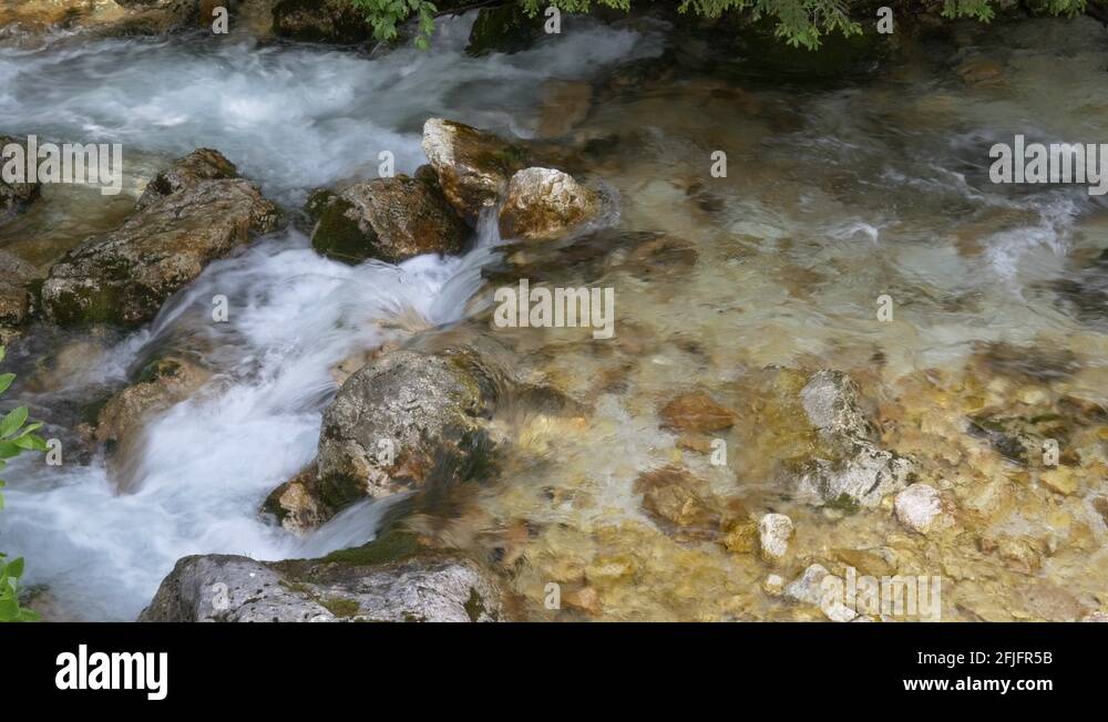 Clear fresh beautiful water running down a stream next to Lake Bled in ...